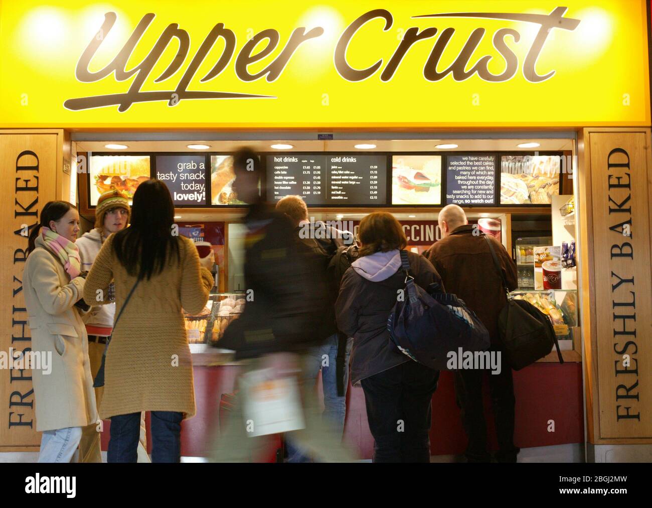 Poeple being served Baguettes at an Upper Crust shop at Euston Station ...