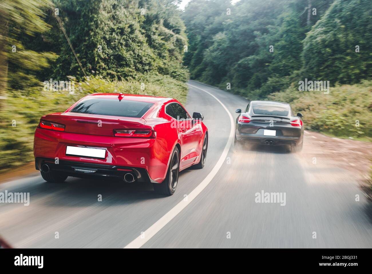 Red and black sport cars passing each other ,view from behind Stock ...