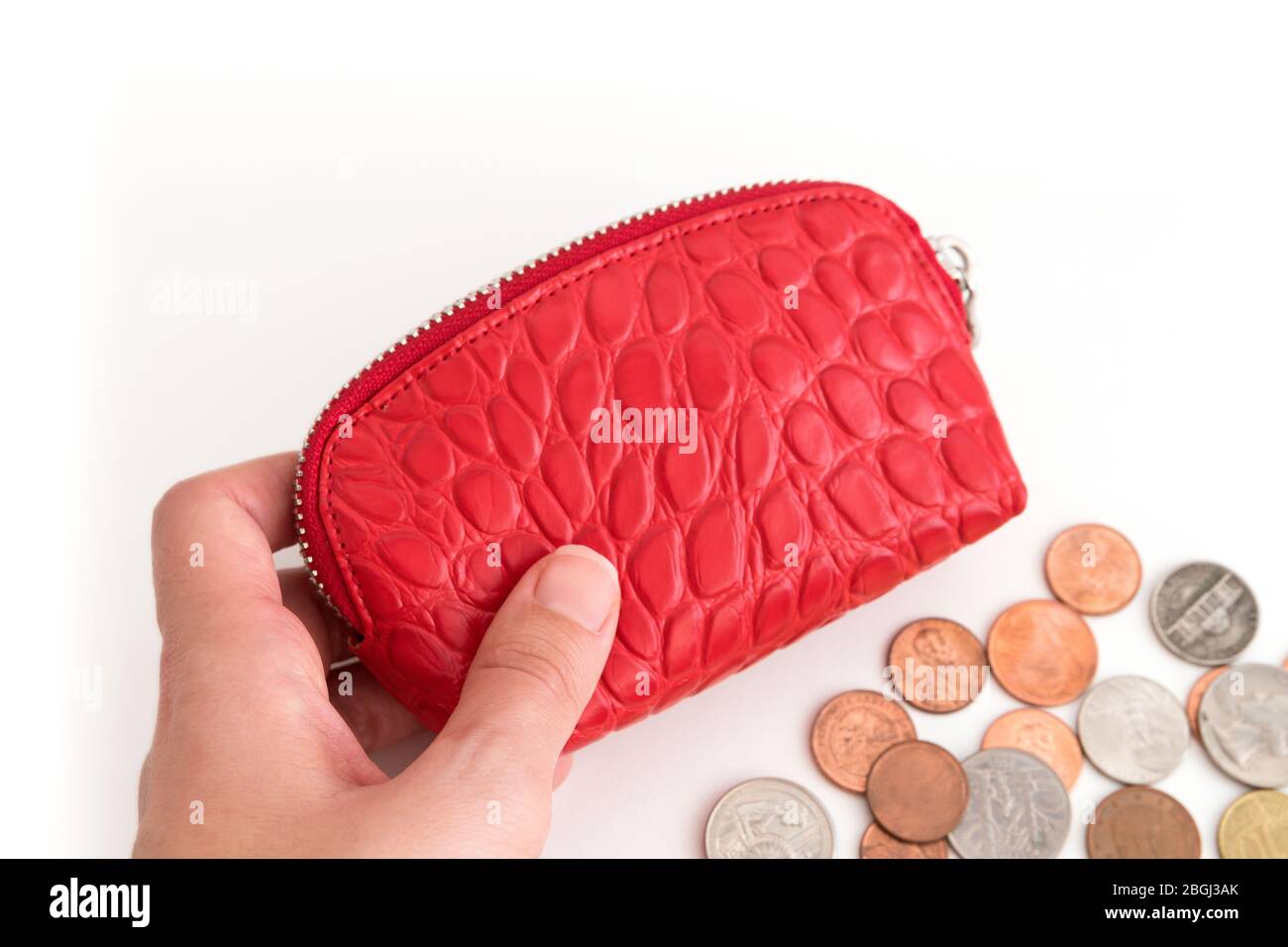 Hand of a woman with a red coin purse in the hands and coins in the ...