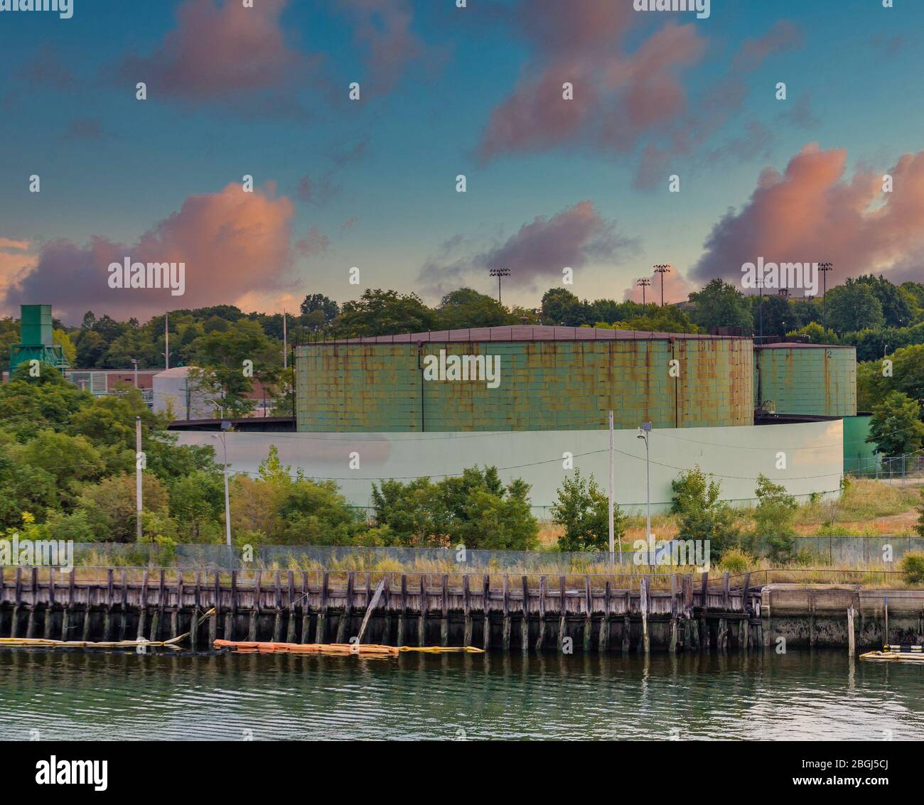 Old, rusty, green industrial tanks on the edge of the sea Stock Photo ...