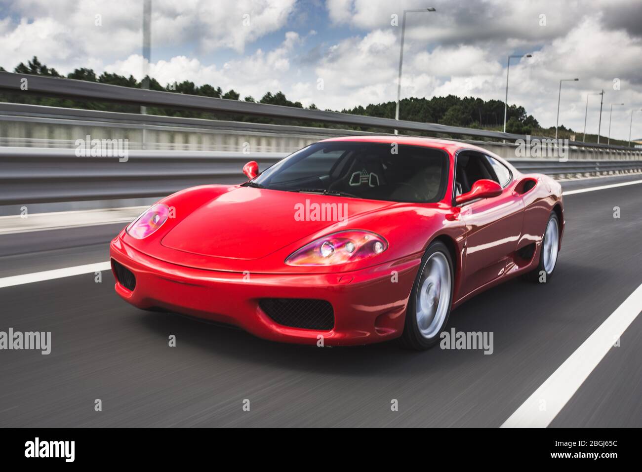 Red supercar racing on the highway under blue sky through landscapes ...