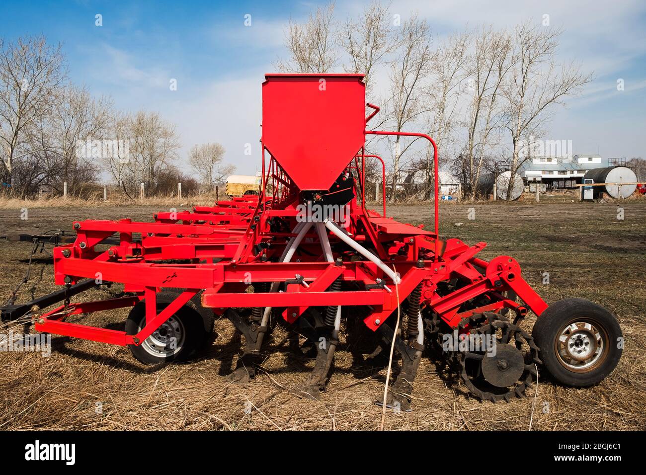 Red combine and plow, trailed sprayer with tank and liquid. Machinery ...