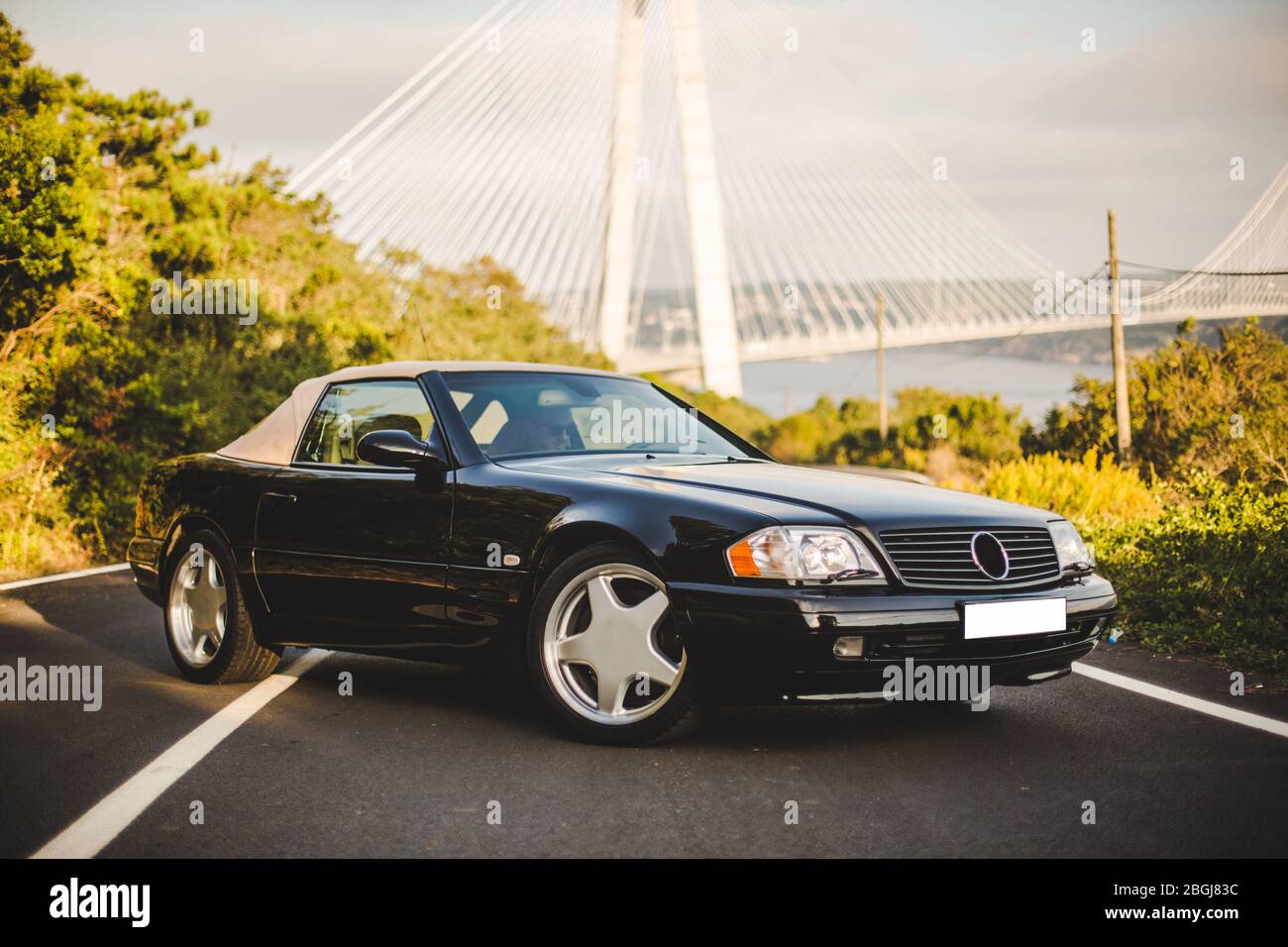 Old model sedan car in the downtown road with bridge and nature view ...