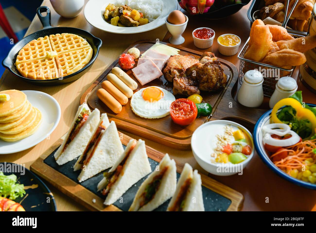 Table with continental dream breakfast food - fruits, eggs, sandwiches ...