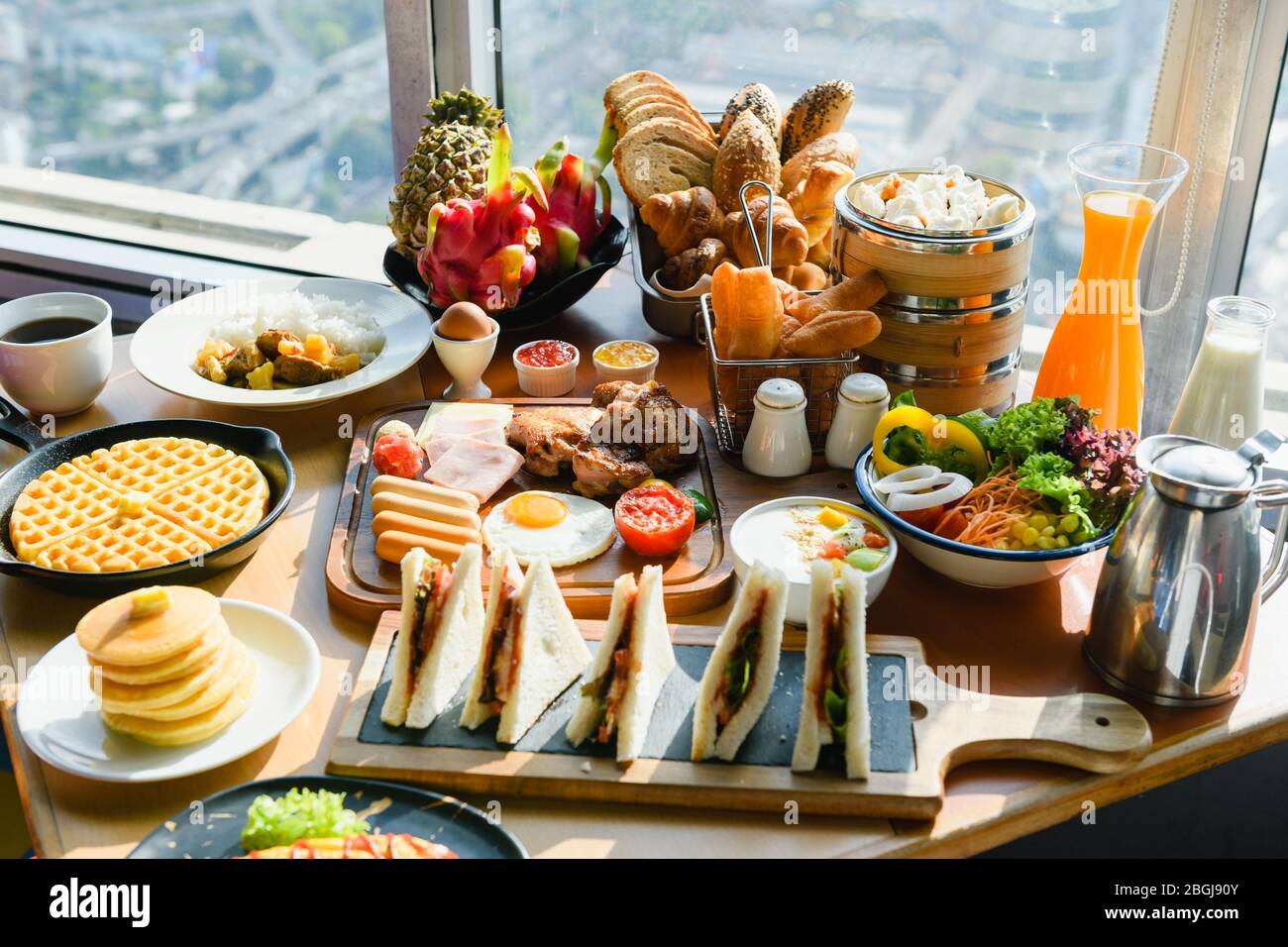 Table with continental dream breakfast food - fruits, eggs, sandwiches ...