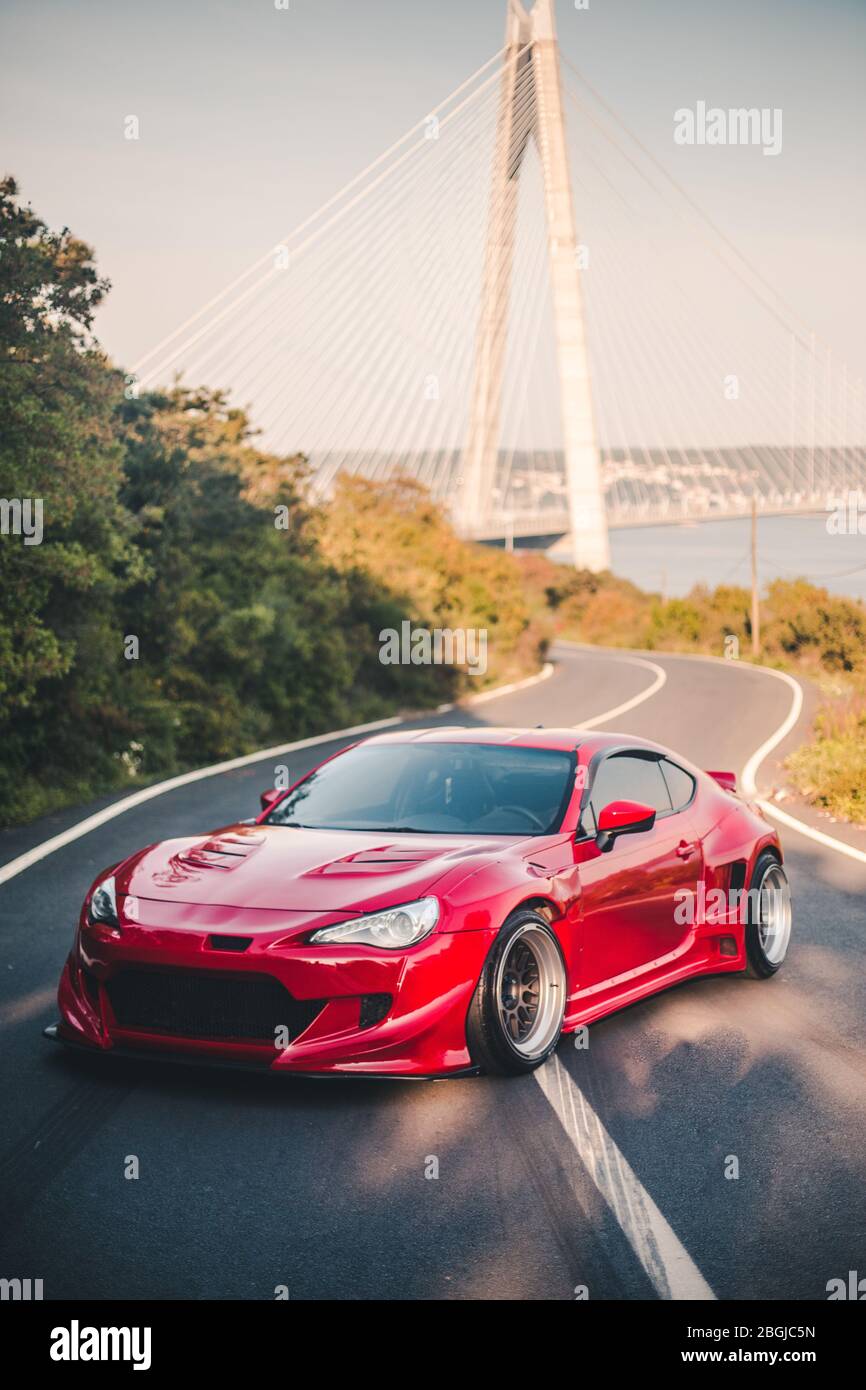 Modern red racing car commercial on the hill with bridge view Stock ...