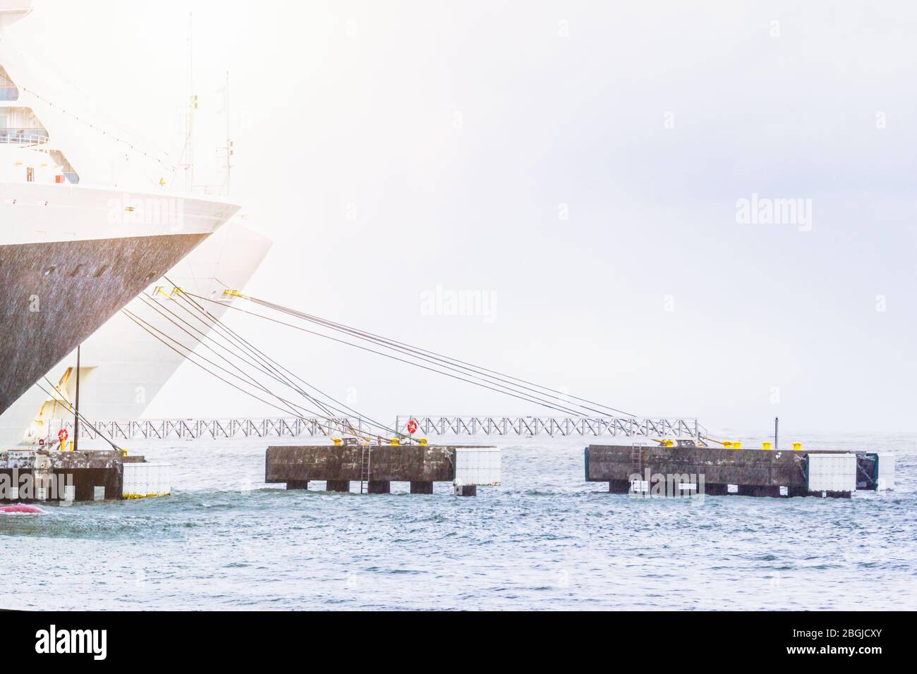 Two cruise ships tied with mooring ropes side be side in the port Stock ...