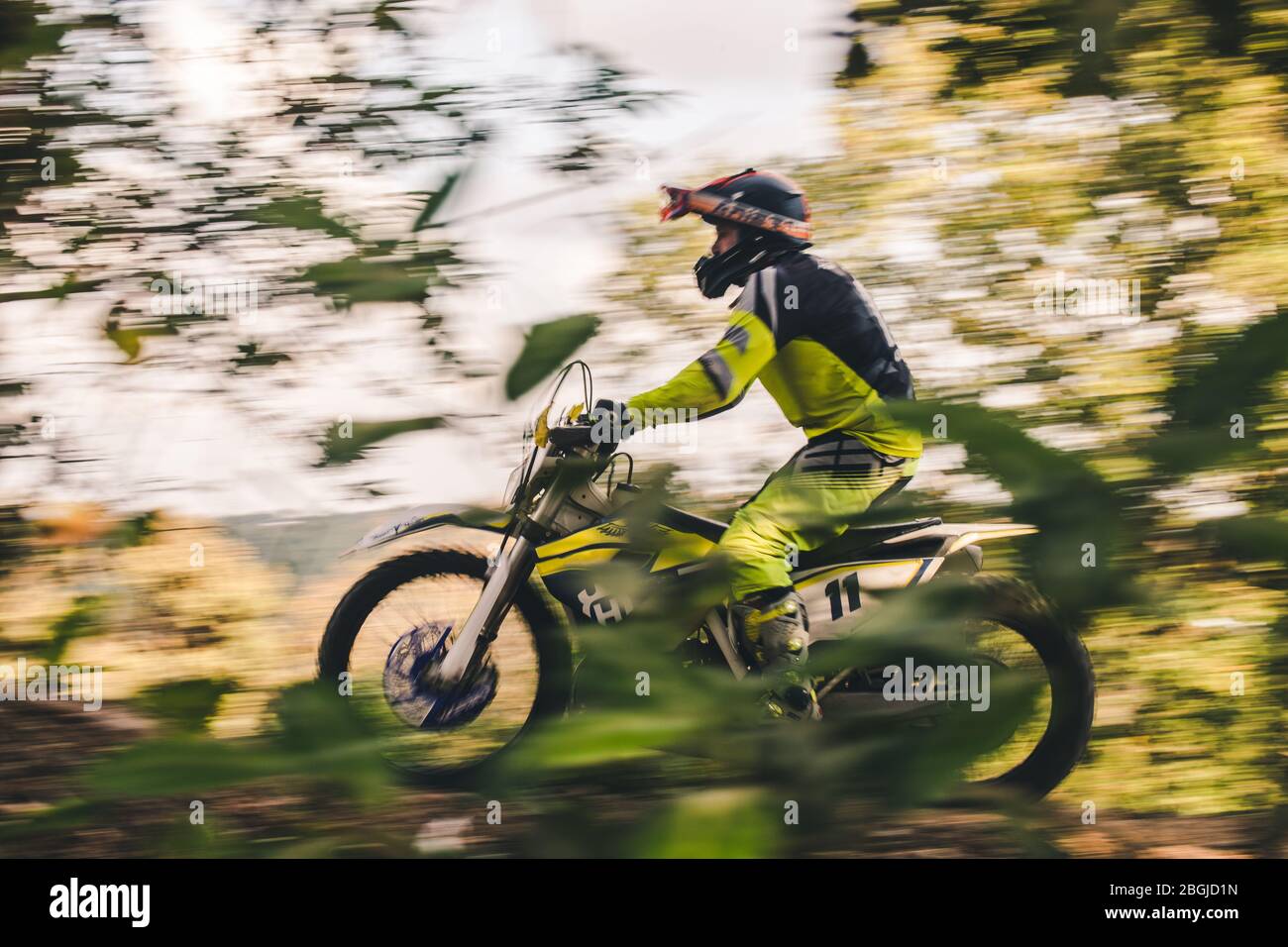 A biker racing with his motorbike in the forest Stock Photo - Alamy