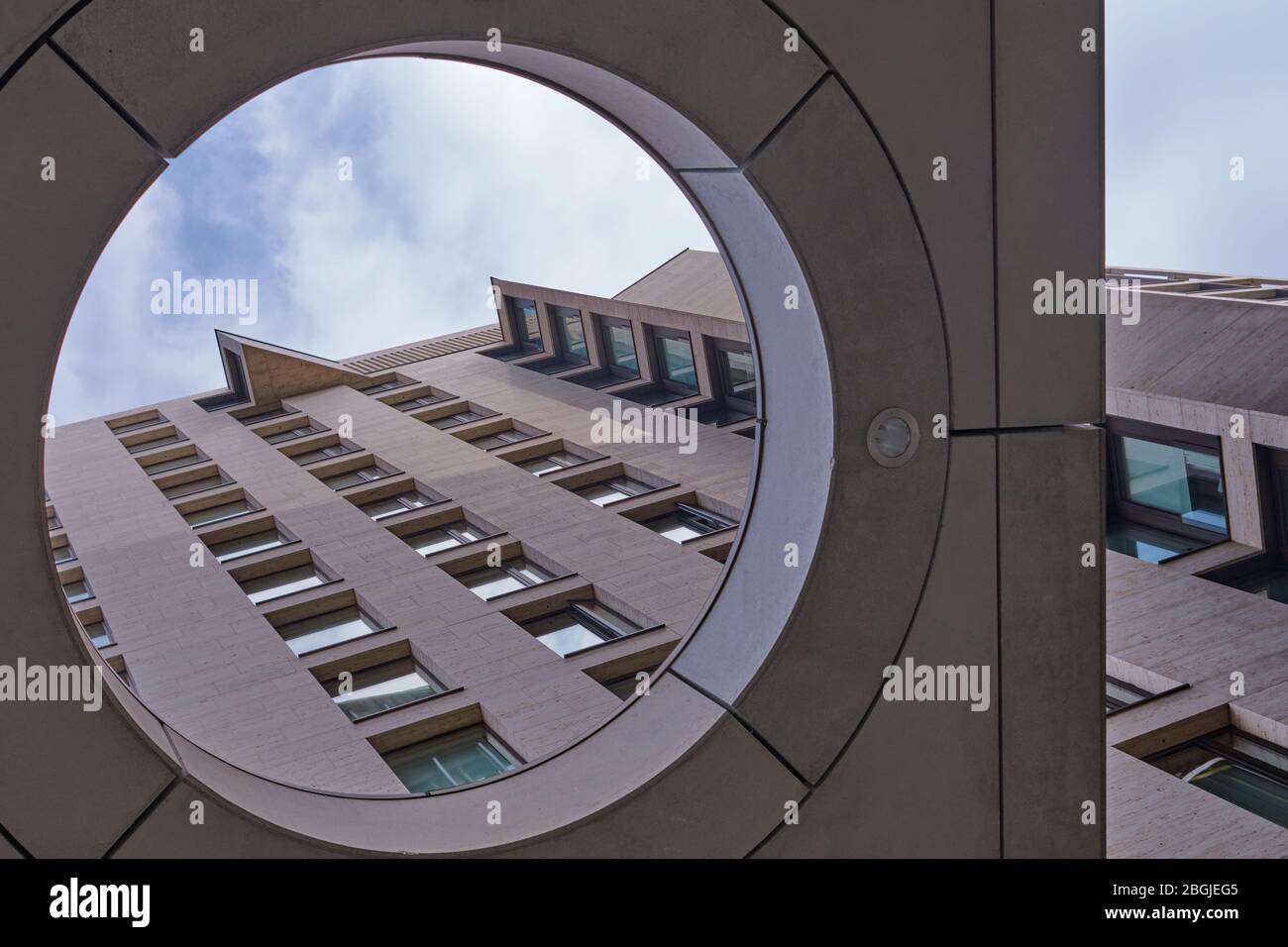 London, UK - 18 April 2020: Looking up through circular hole to tall ...