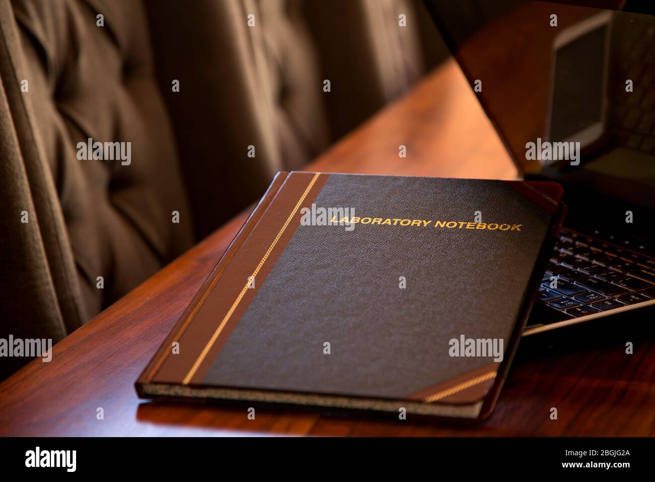 Laboratory notebook, laptop, and mobile phone on wood business meeting ...