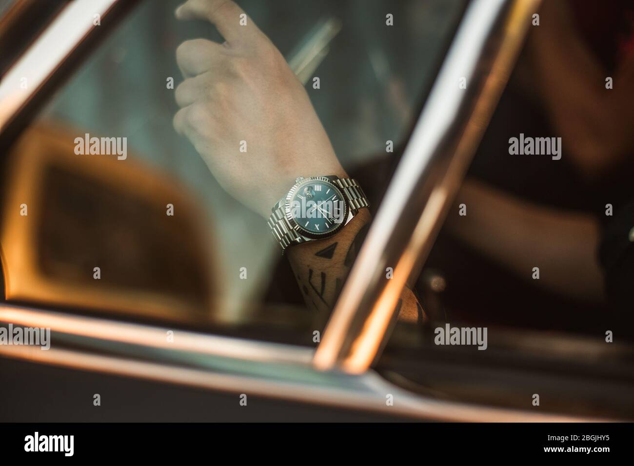 Driver hand and watch through window of a car Stock Photo - Alamy