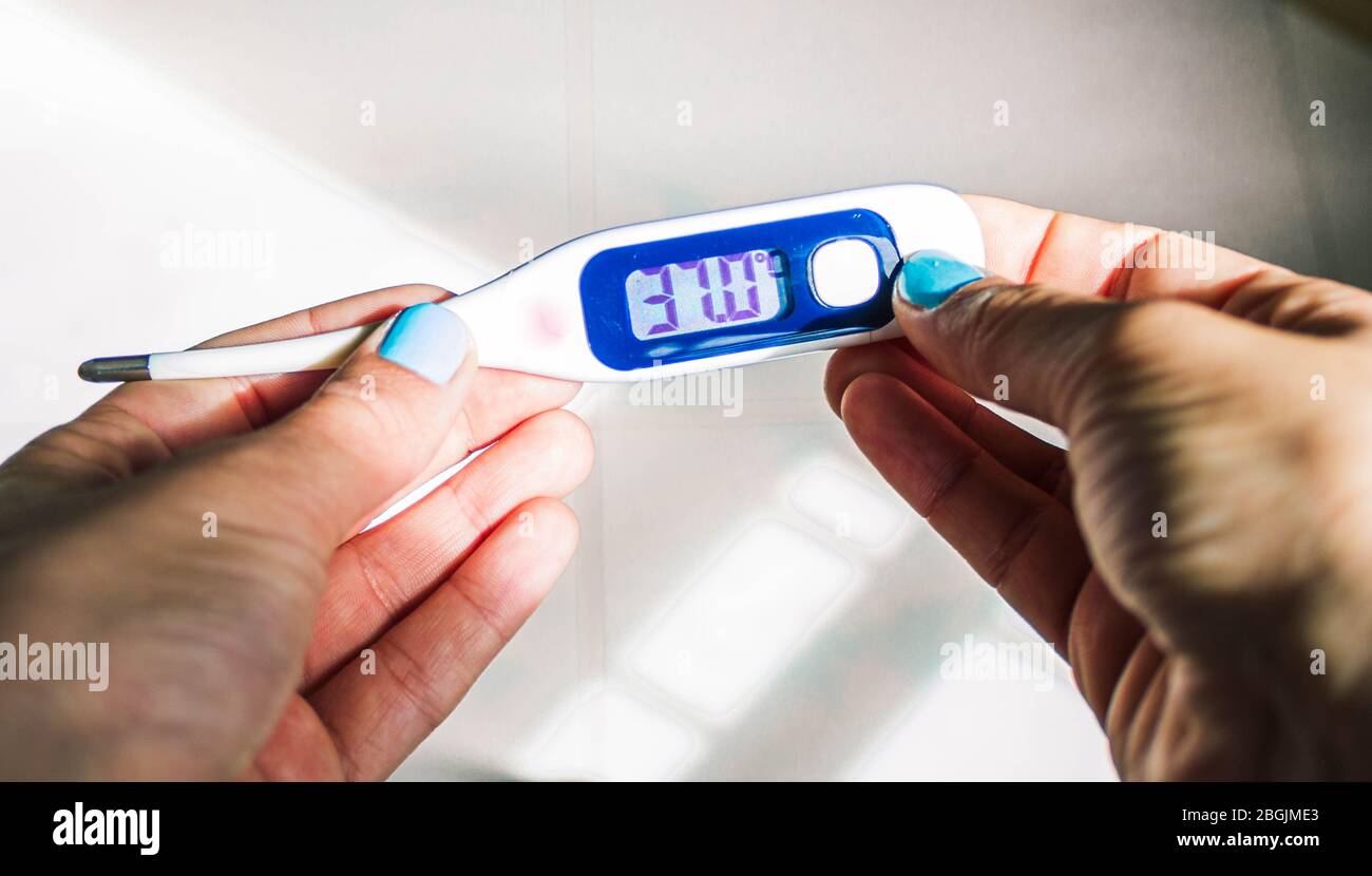 female hands holding a thermometer Stock Photo - Alamy