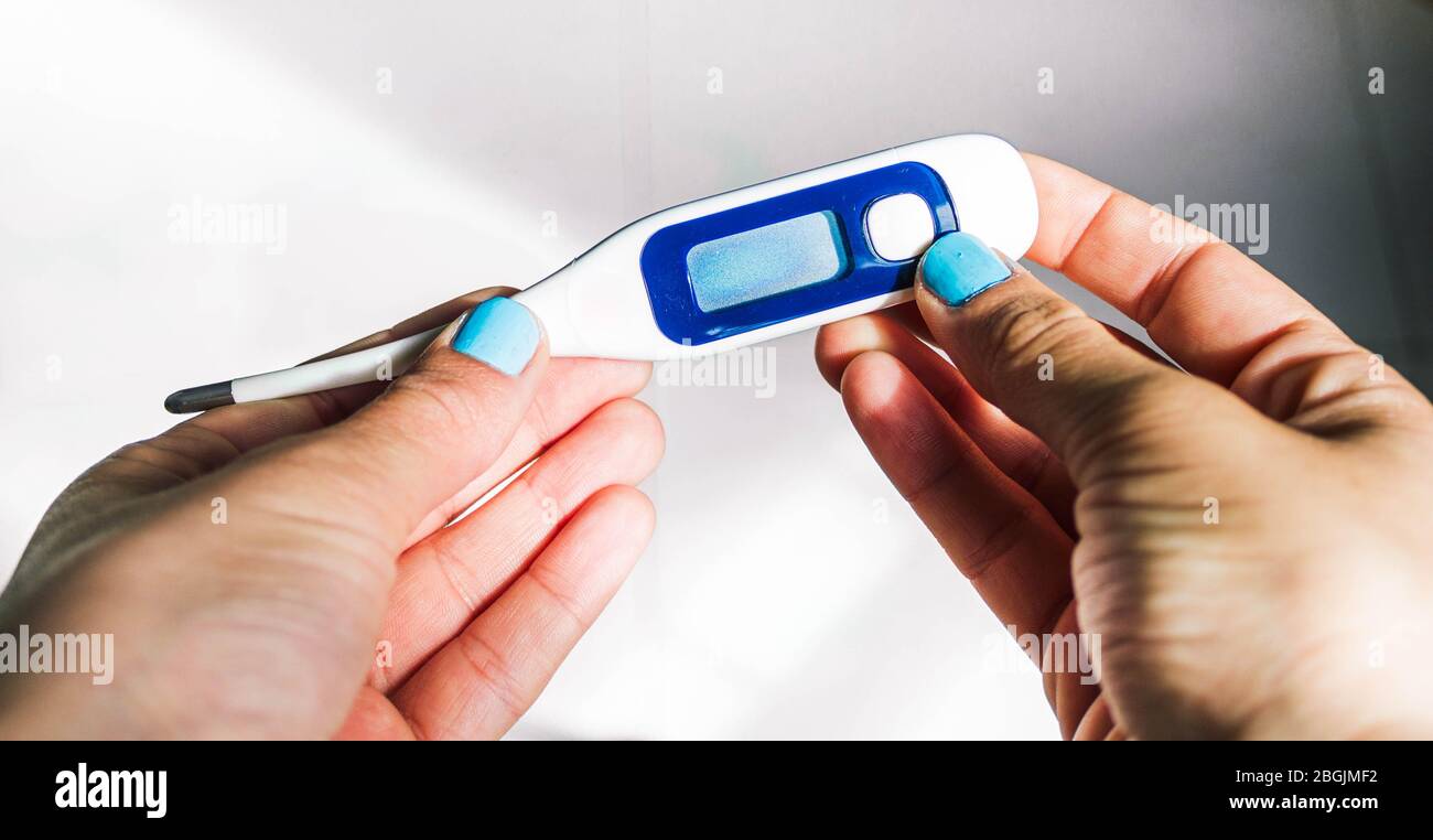 female hands holding a thermometer Stock Photo - Alamy