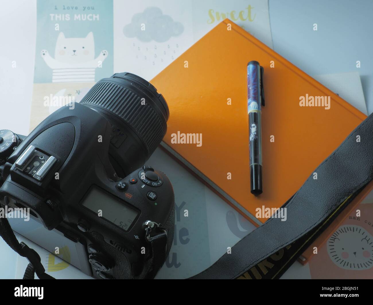 microstock photographer home desk setup with camera, pen and notes ...