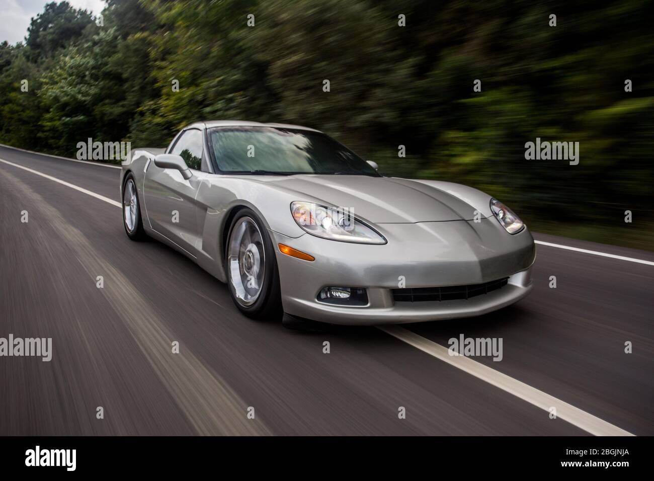 Silver supercar speed performance on the forest road Stock Photo - Alamy