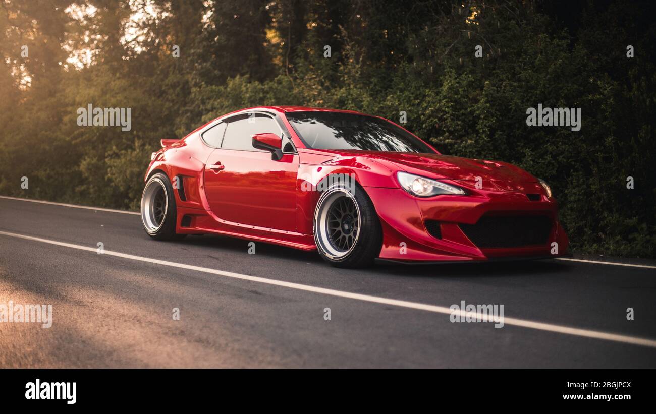 Modern red racing car commercial in the forest Stock Photo - Alamy