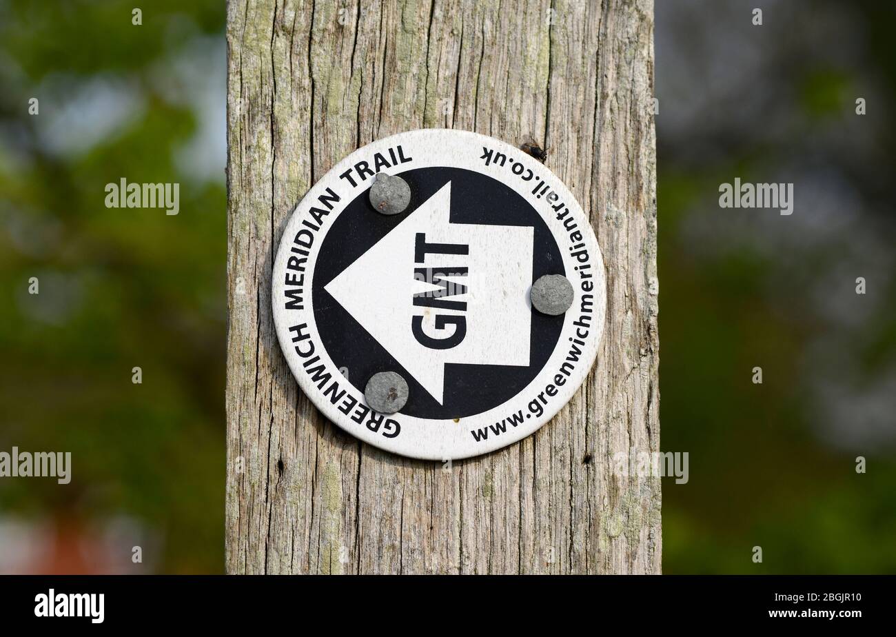 A sign on a wooden pole points the way of the Greenwich Meridian Trail ...