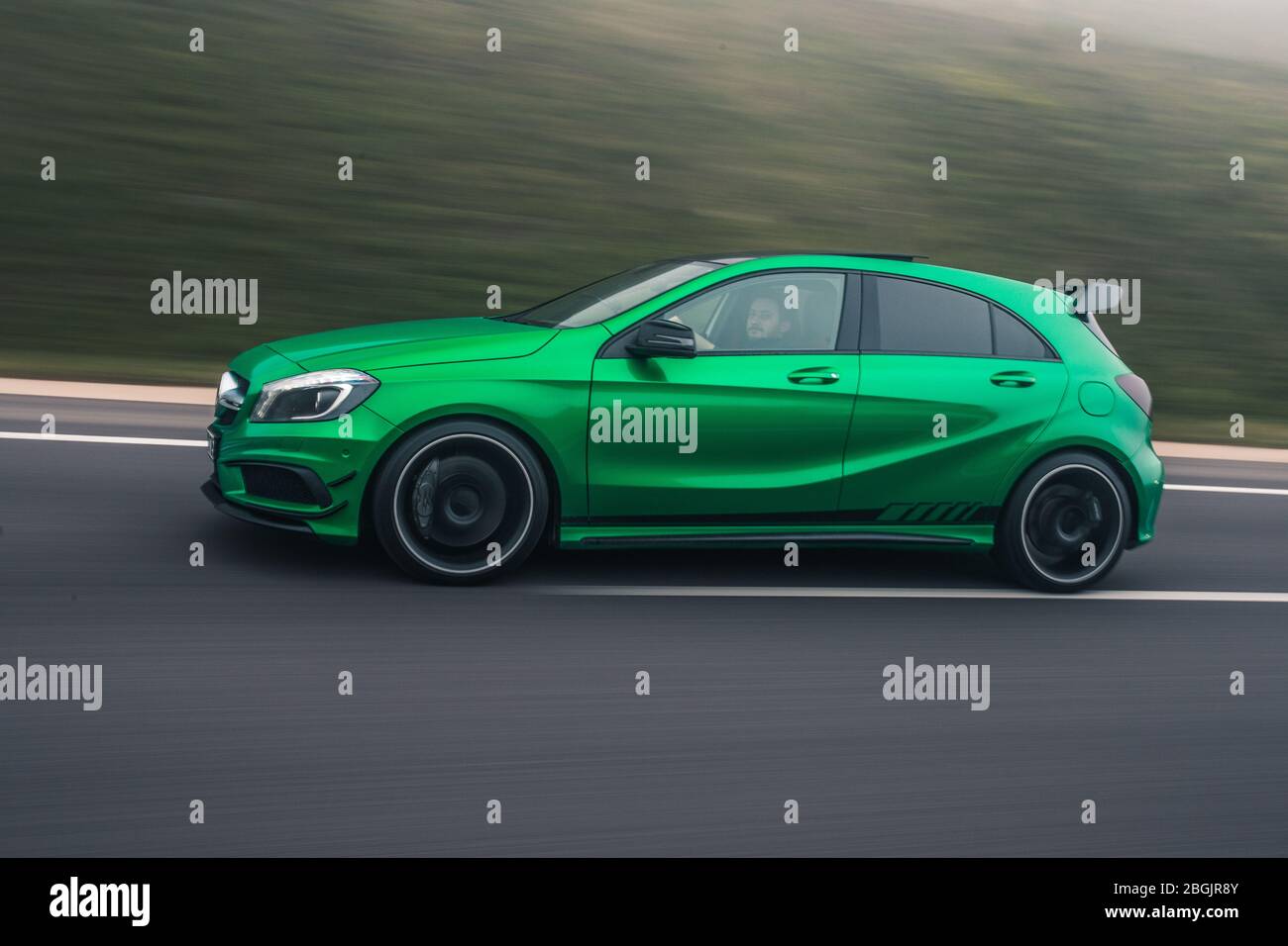 Green racing car, performance autoshow in the foggy weather,profile ...