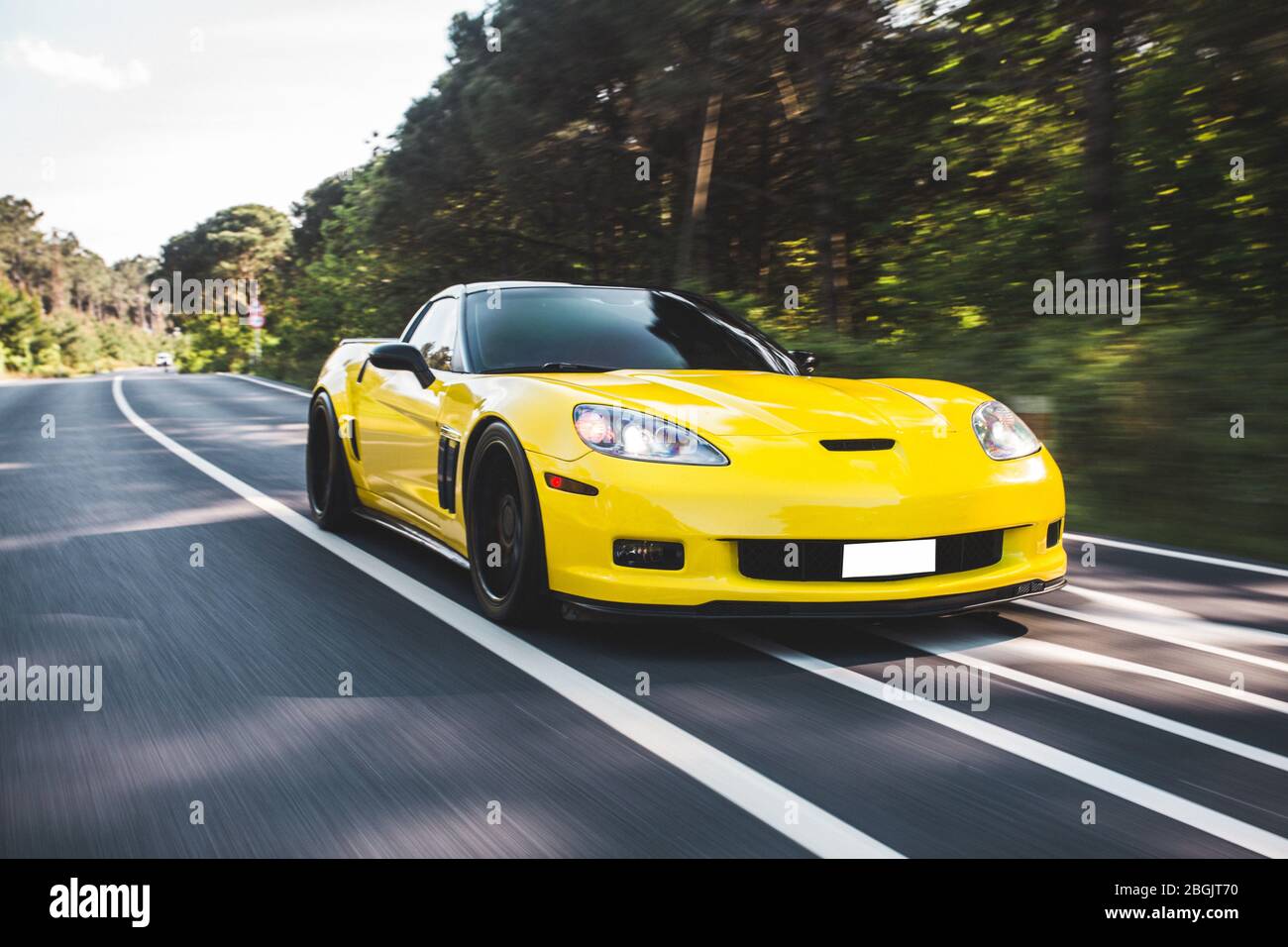 Yellow racing car with red xenon lights, forest rush Stock Photo - Alamy