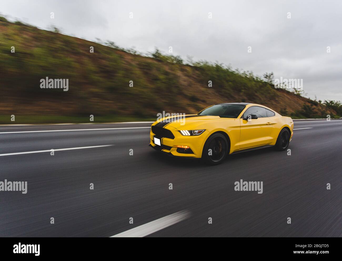 Yellow sport car with black stripe in the racing track over the ...