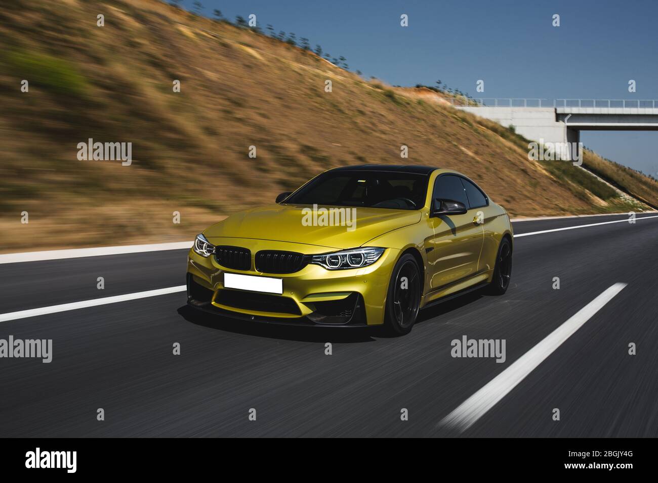 Yellow racecar travelling on the highway across deserts and highlands ...