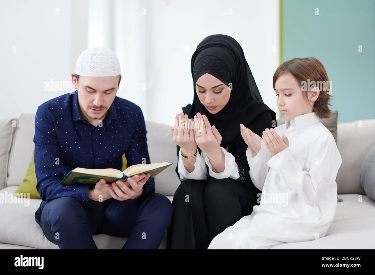 Traditional muslim family parents with children reading Quran and ...
