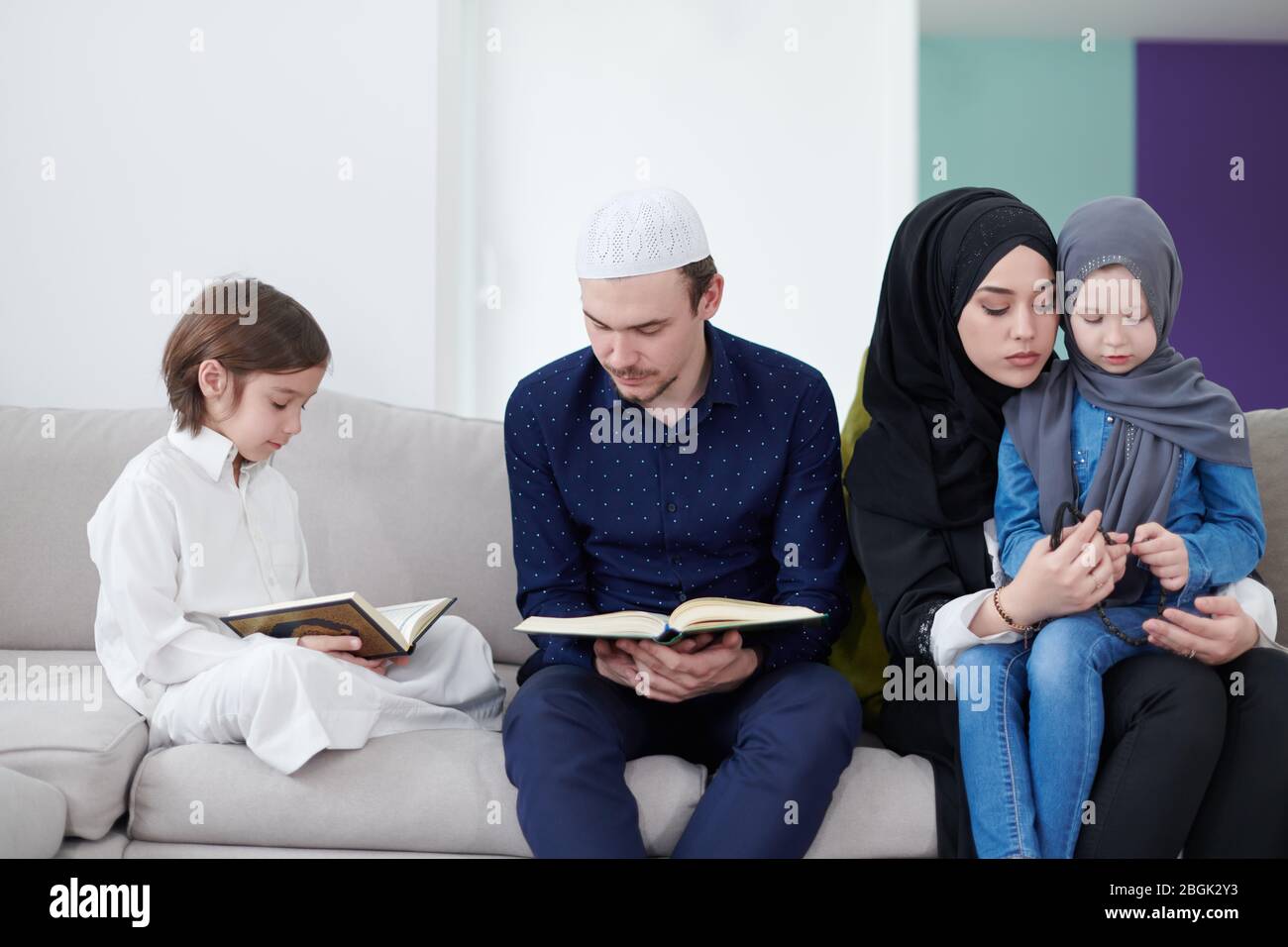 Traditional muslim family parents with children reading Quran and ...