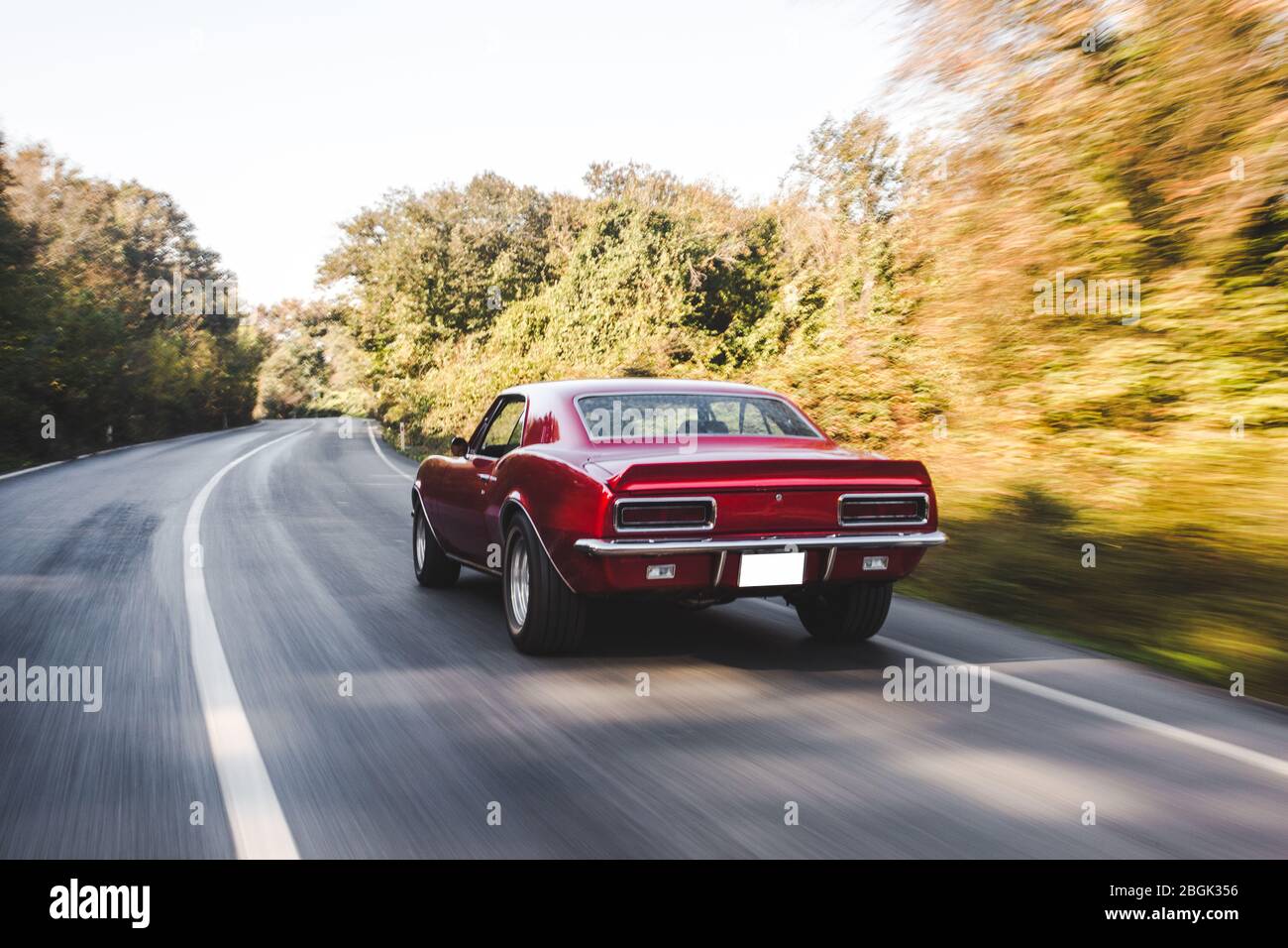 Red old fashioned vintage sedan in the forest Stock Photo - Alamy