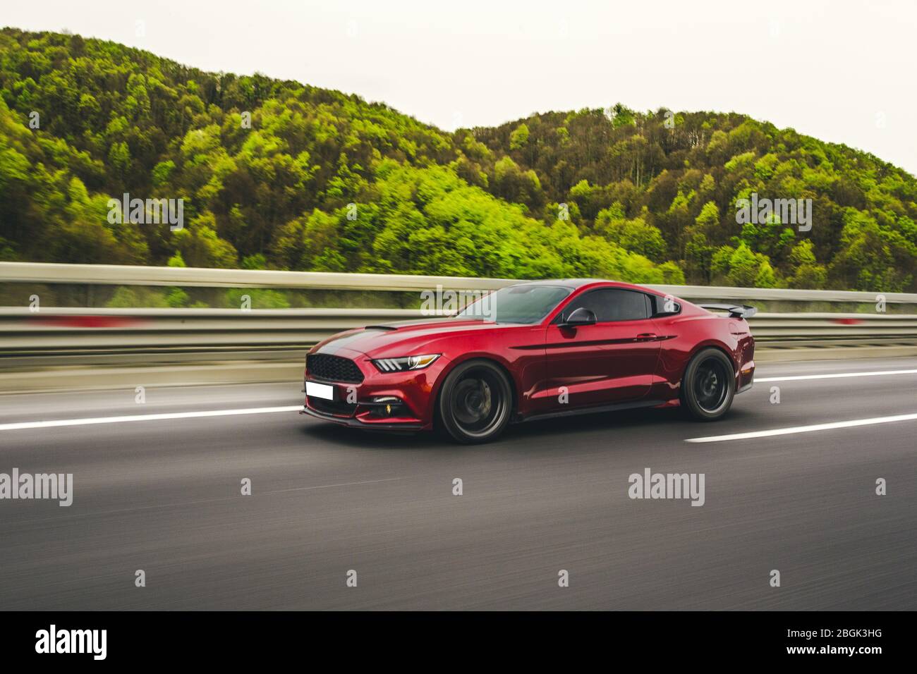 Red sport car driving on the freeway in a sunny day, in the green ...