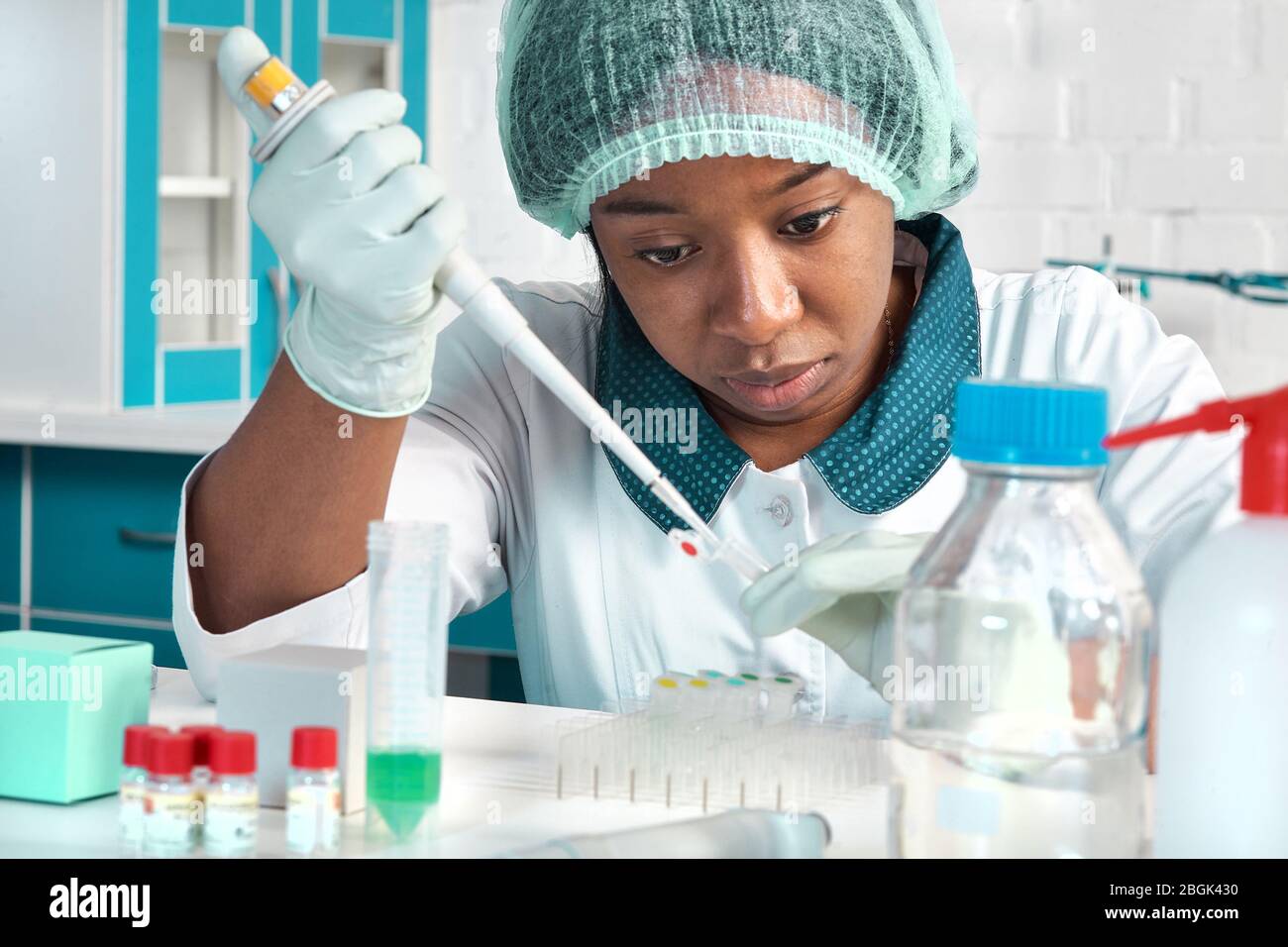 African scientist, technical assistant in lab coat, protective hat and ...