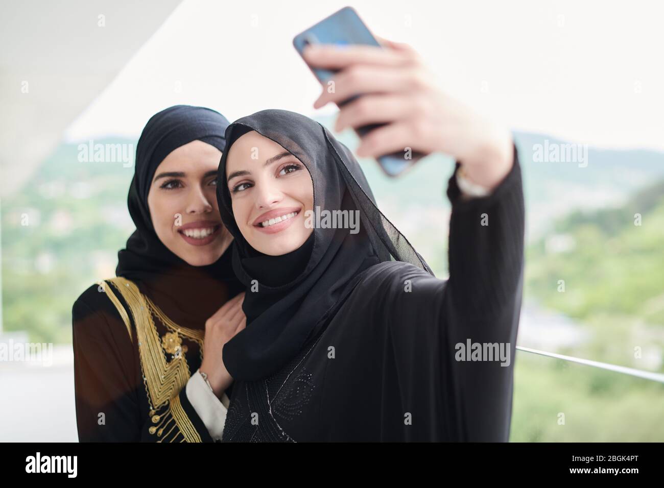 young beautiful muslim women in fashionable dress with hijab using ...