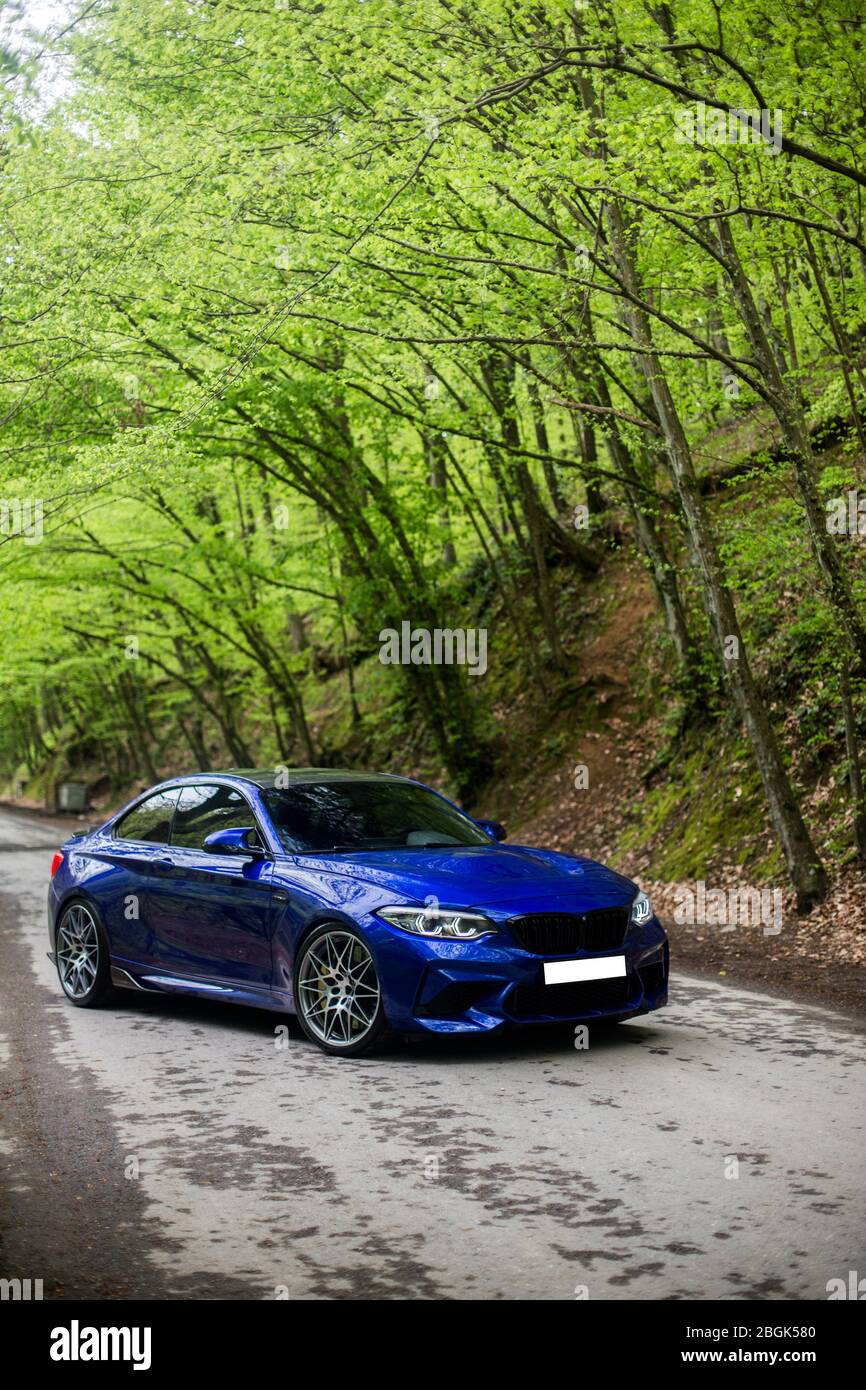 Blue sedan parked in the romantic forest Stock Photo - Alamy