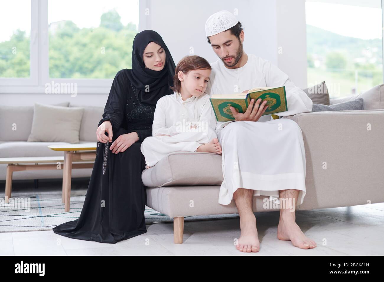 Traditional muslim family parents with children reading Quran and ...