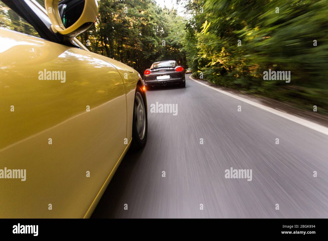 Black cars driving on the transit freeway in the sunset, yellow car ...