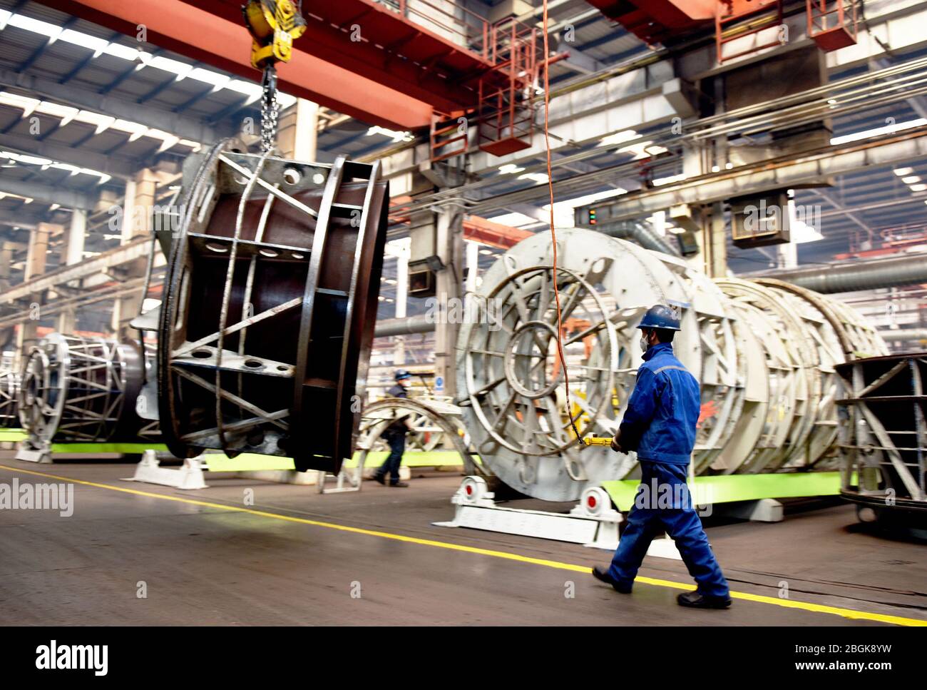 Workers are busy at assembling construction machines along automatic ...