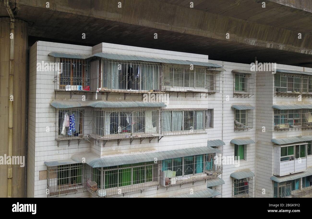 An aerial view of a row of apartment buildings standing under a viaduct ...