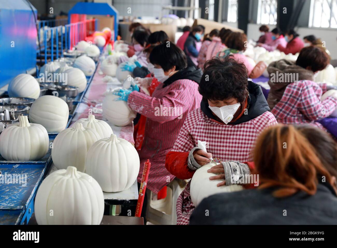Workers are busy at assembling festival decorations and toys along ...