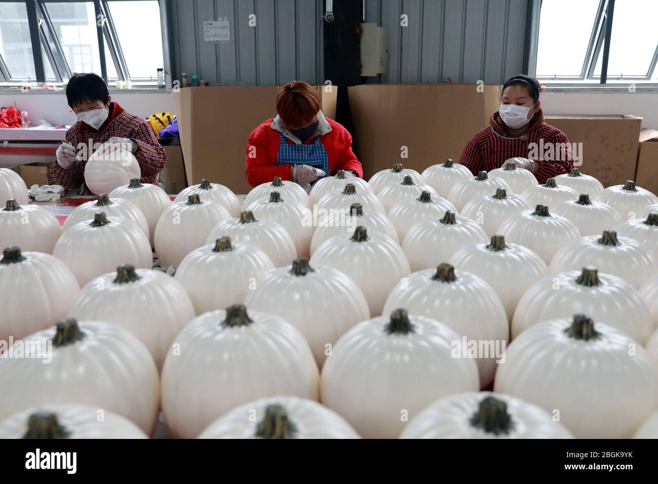 Workers are busy at assembling festival decorations and toys along ...