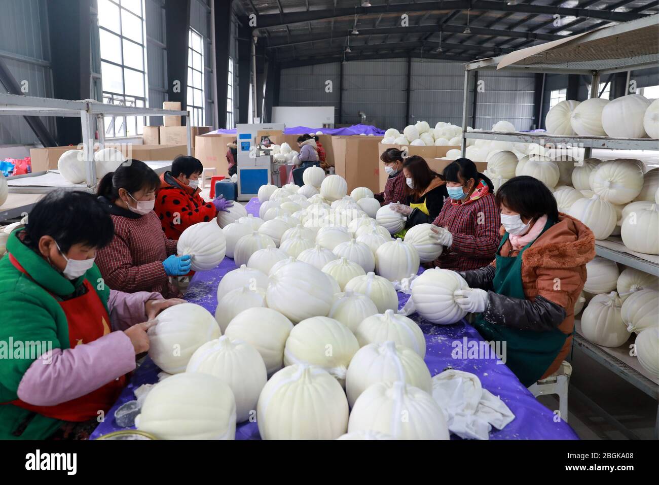 Workers are busy at assembling festival decorations and toys along ...