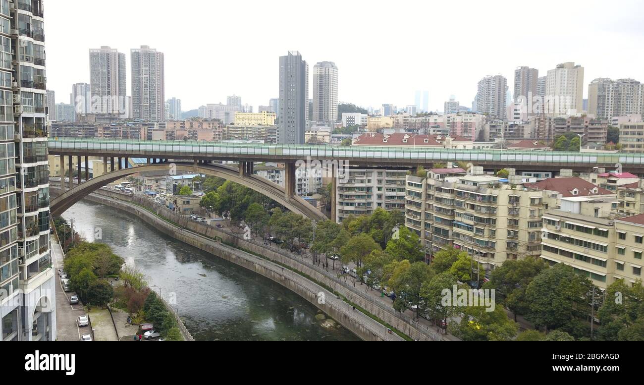 An aerial view of a row of apartment buildings standing under a viaduct ...