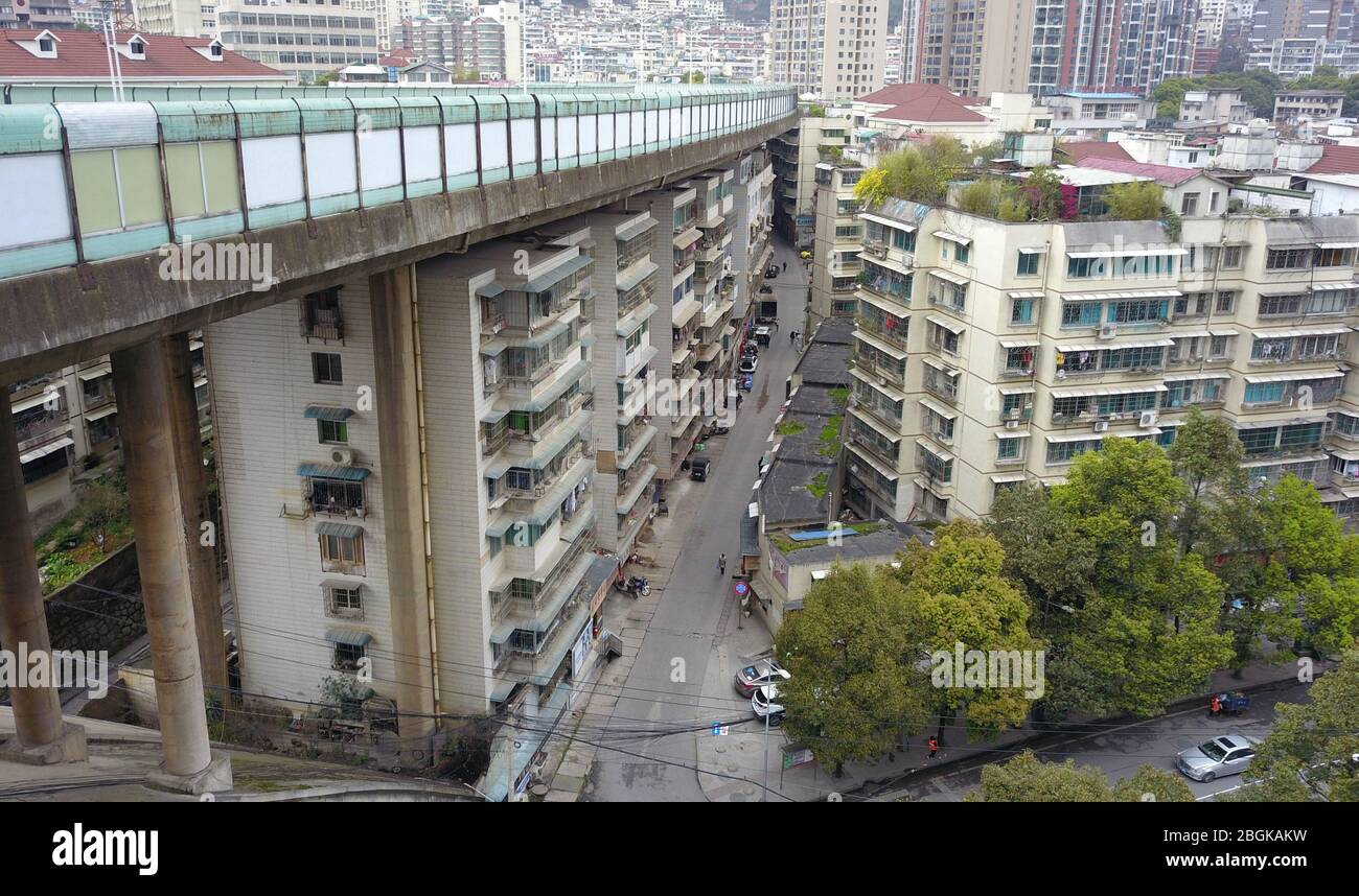 An aerial view of a row of apartment buildings standing under a viaduct ...