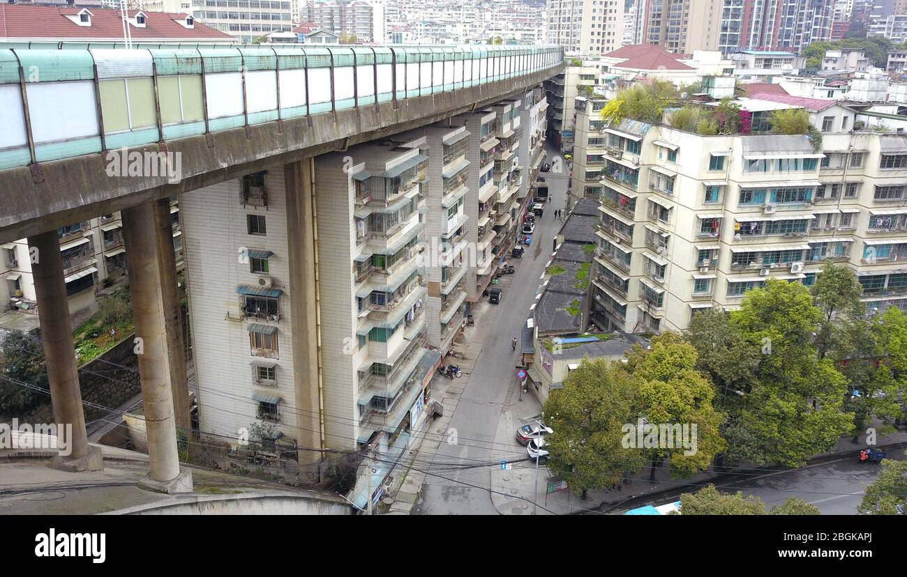 An aerial view of a row of apartment buildings standing under a viaduct ...