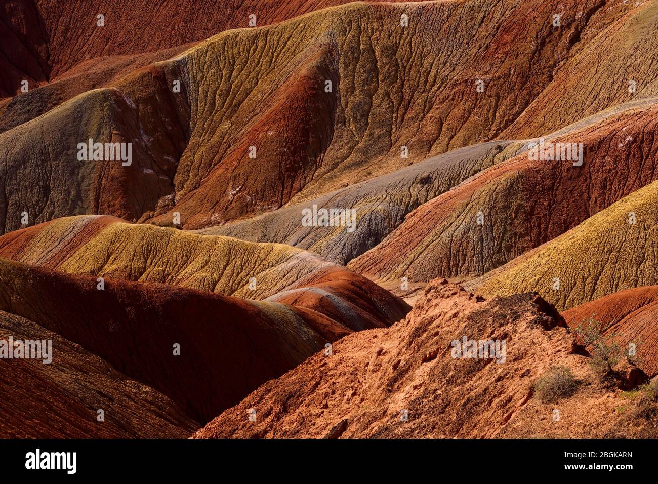 An aerial of mountains of Danxia Landform with colorful strips at Qicai ...