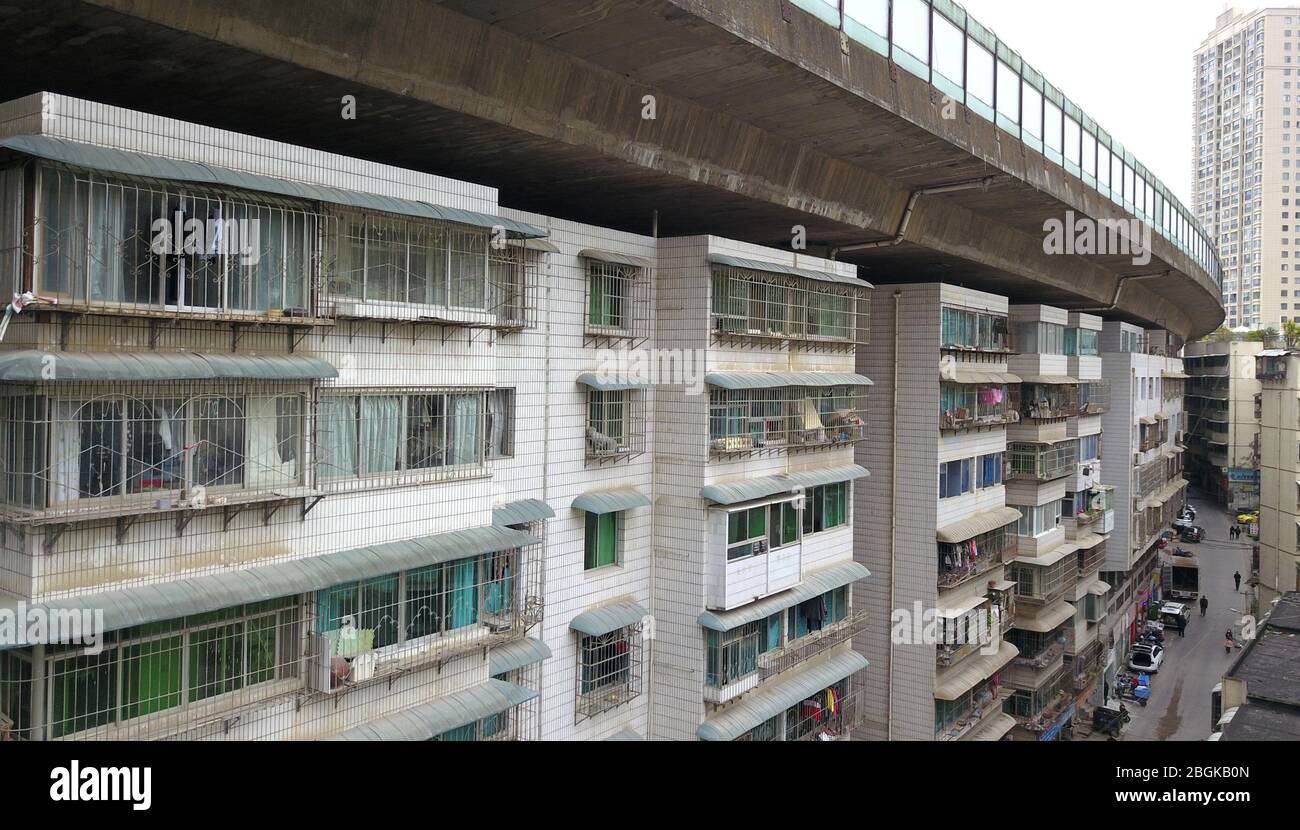 An aerial view of a row of apartment buildings standing under a viaduct ...