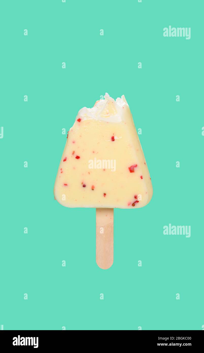 white chocolate outer popsicle with a bite on green background Stock ...