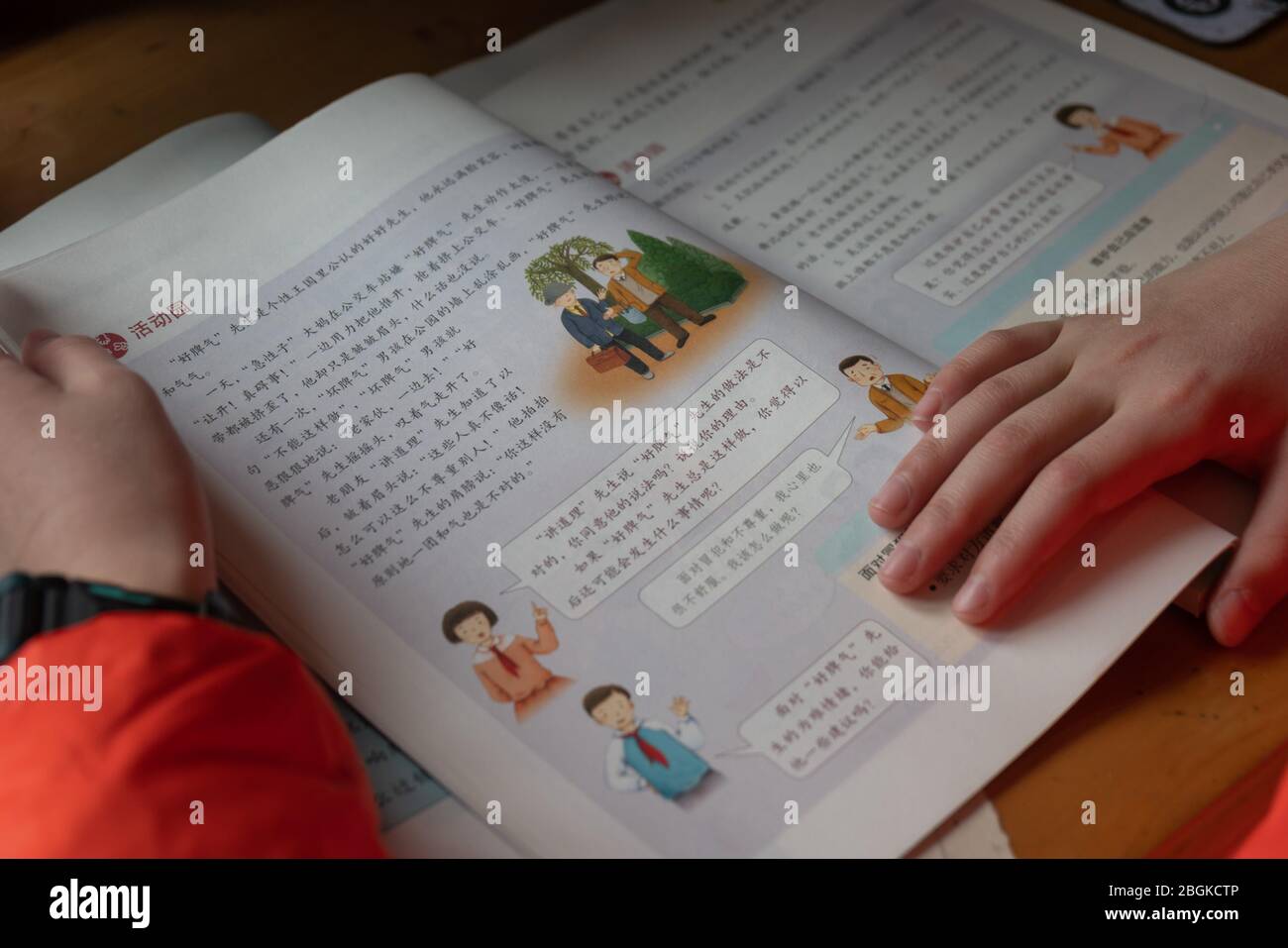 A primary school student does homework while taking classes via ...