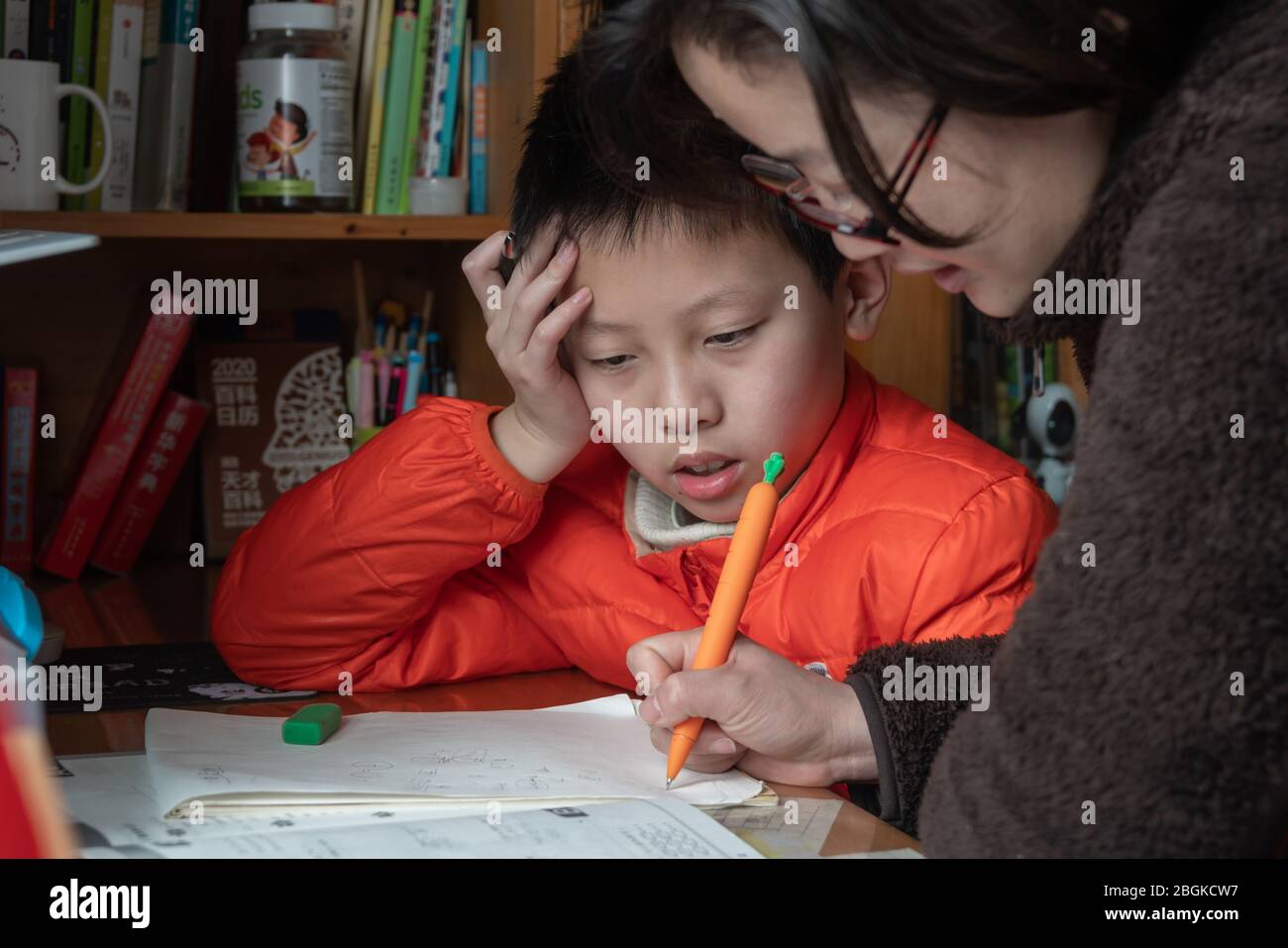 A primary school student does homework while taking classes via ...