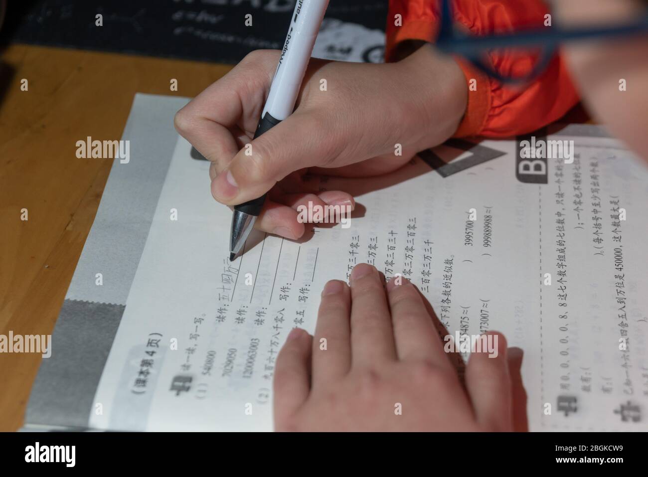 A primary school student does homework while taking classes via ...