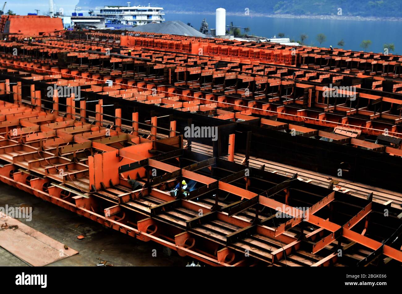 Staff work to produce a large vessel at a ship factory along the ...