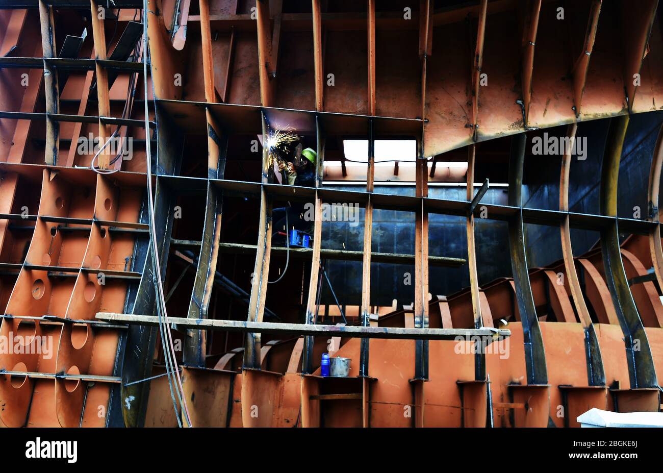 Staff work to produce a large vessel at a ship factory along the ...